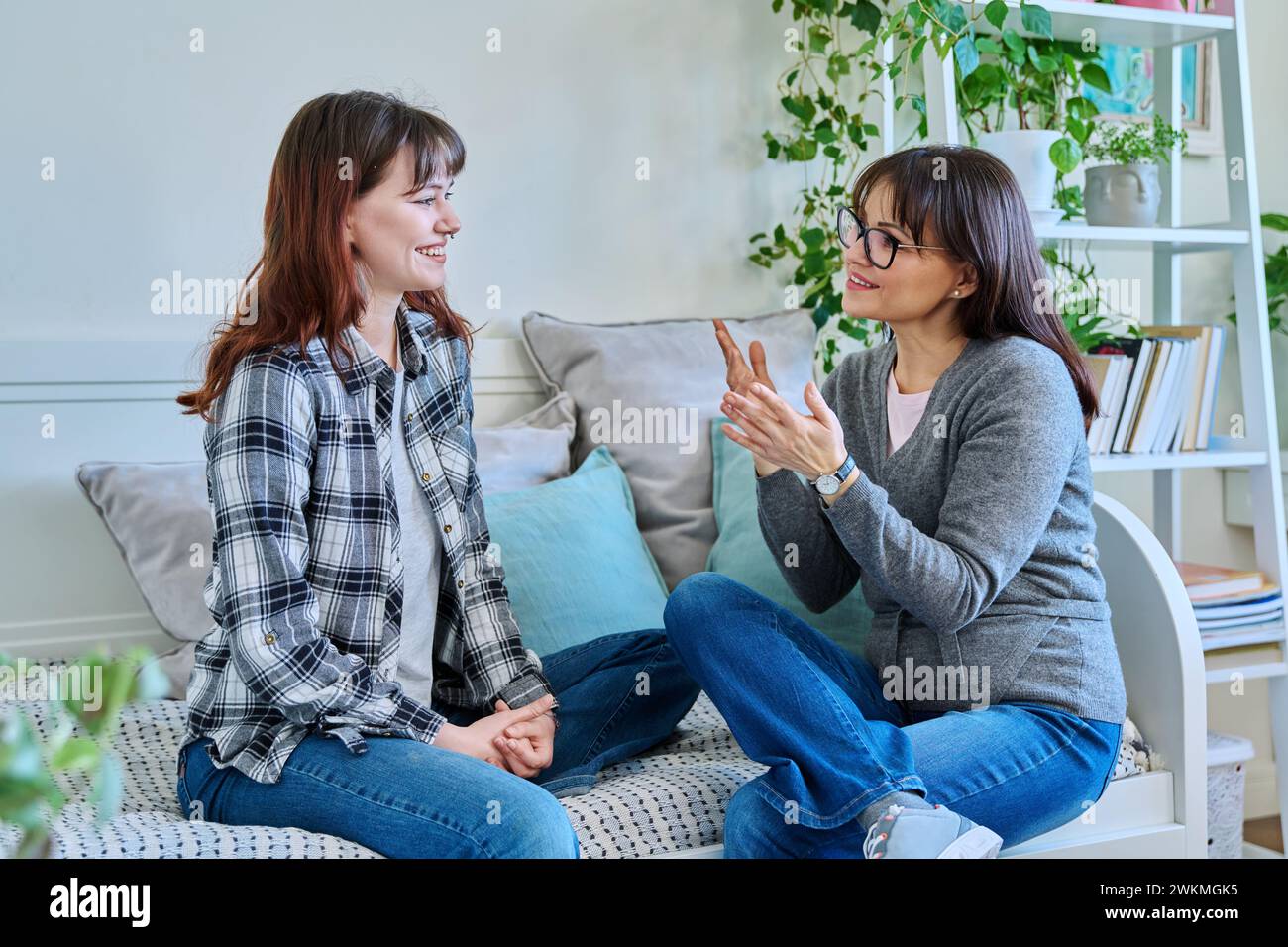 Talking mother and teenage daughter sitting together on couch at home Stock Photo - Alamy