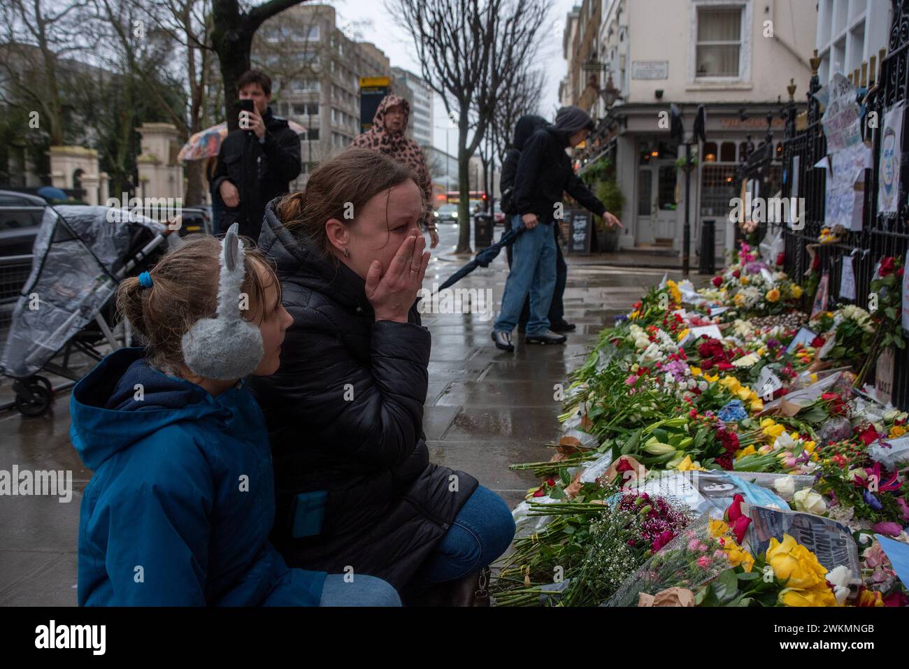 London, UK. 21st Feb, 2024. A mourner cries in front of the floral ...