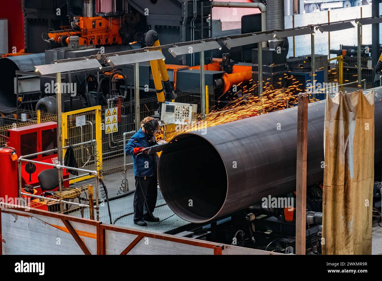 Worker cleans welded seam on steel pipe using grinding machine Stock ...