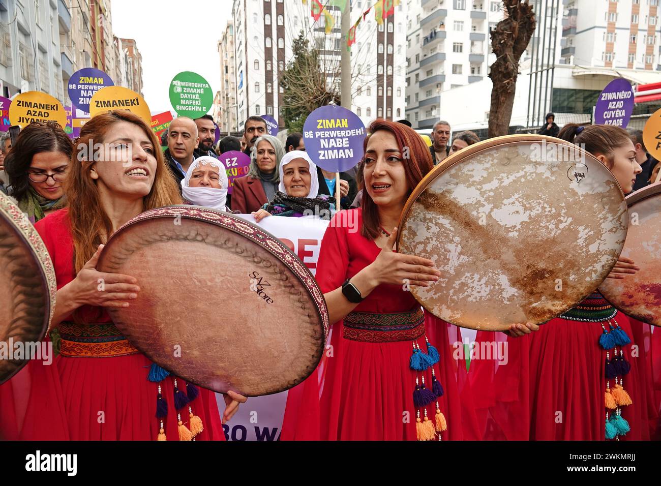 Kurdish women in national costumes are seen playing tambourines and ...