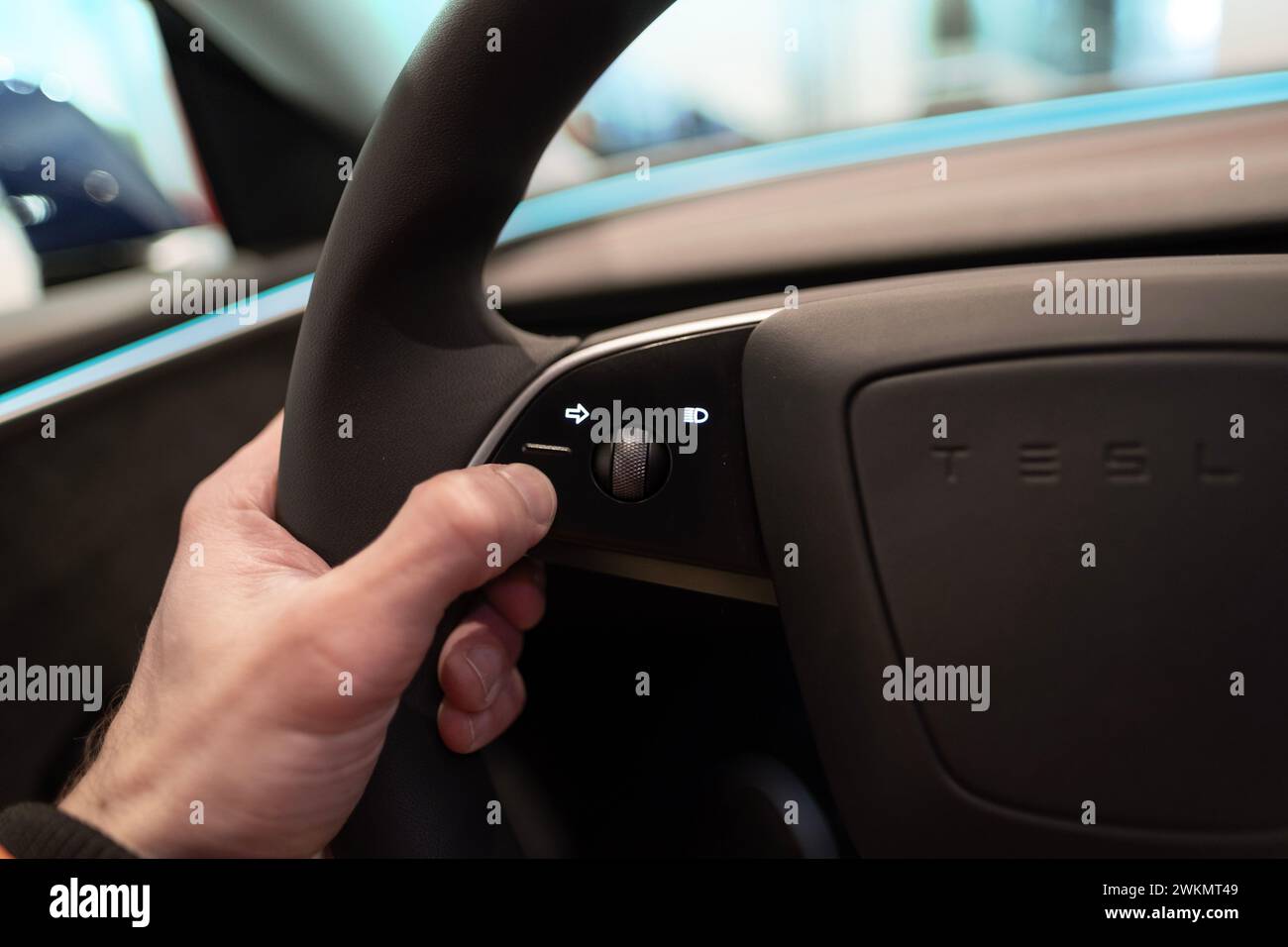 close-up male hand on steering wheel manipulates on electronic switches ...