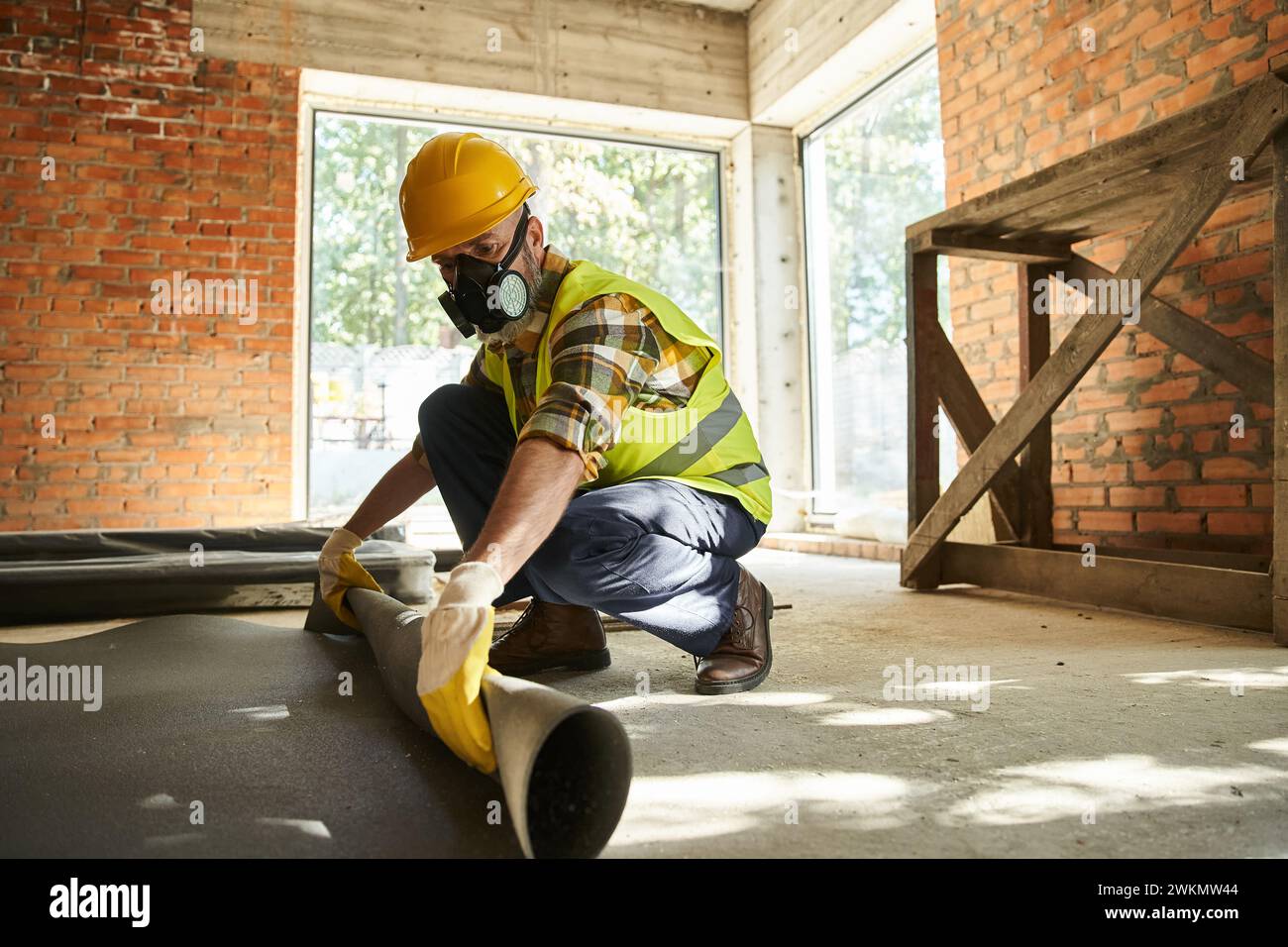 hardworking construction worker in safety helmet and gloves with dust ...