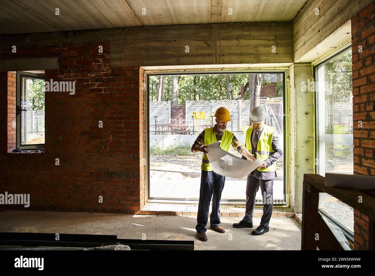 handsome cottage builder and architect and with safety gear working ...
