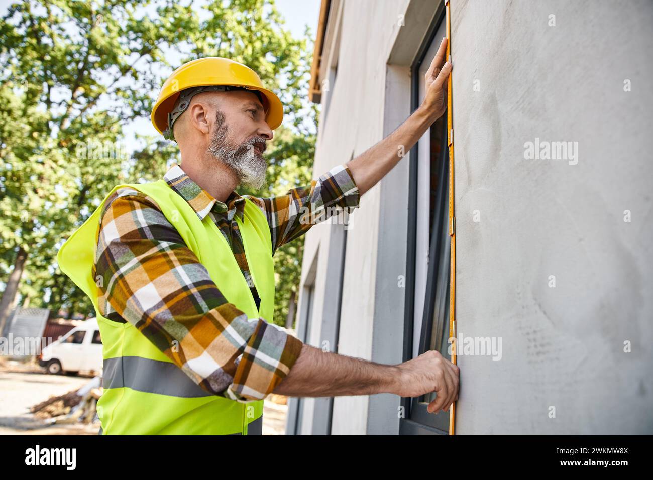 good looking hardworking construction worker with beard measuring ...