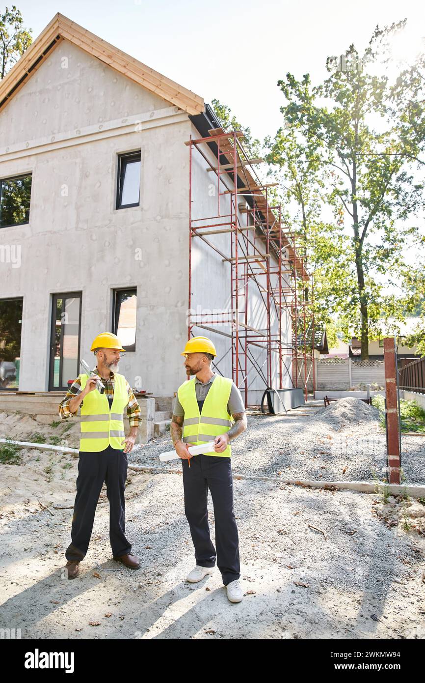 appealing devoted construction workers with level and blueprint looking ...