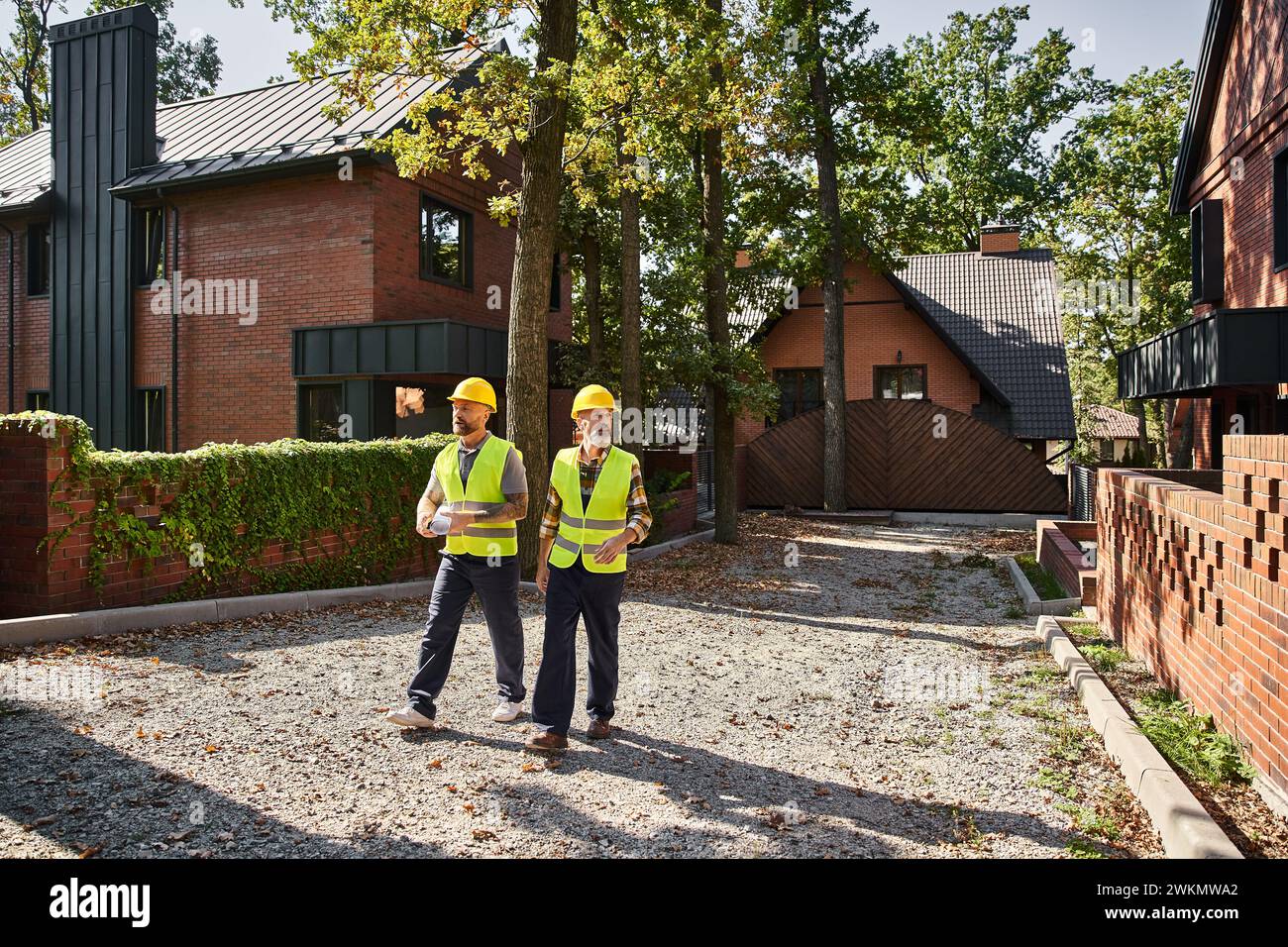 good looking construction workers in safety helmets walking and ...