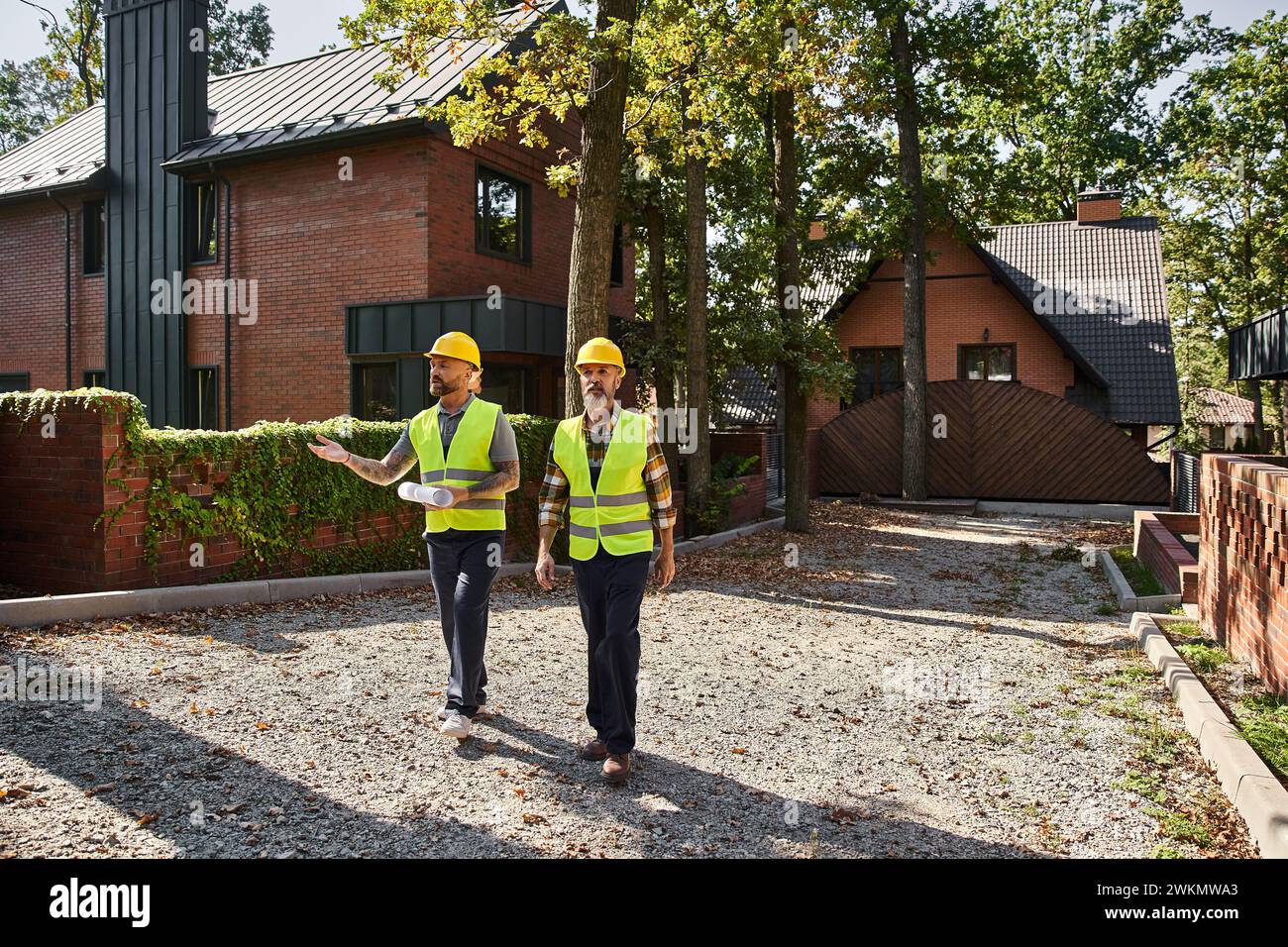 attractive construction workers in safety helmets walking and ...