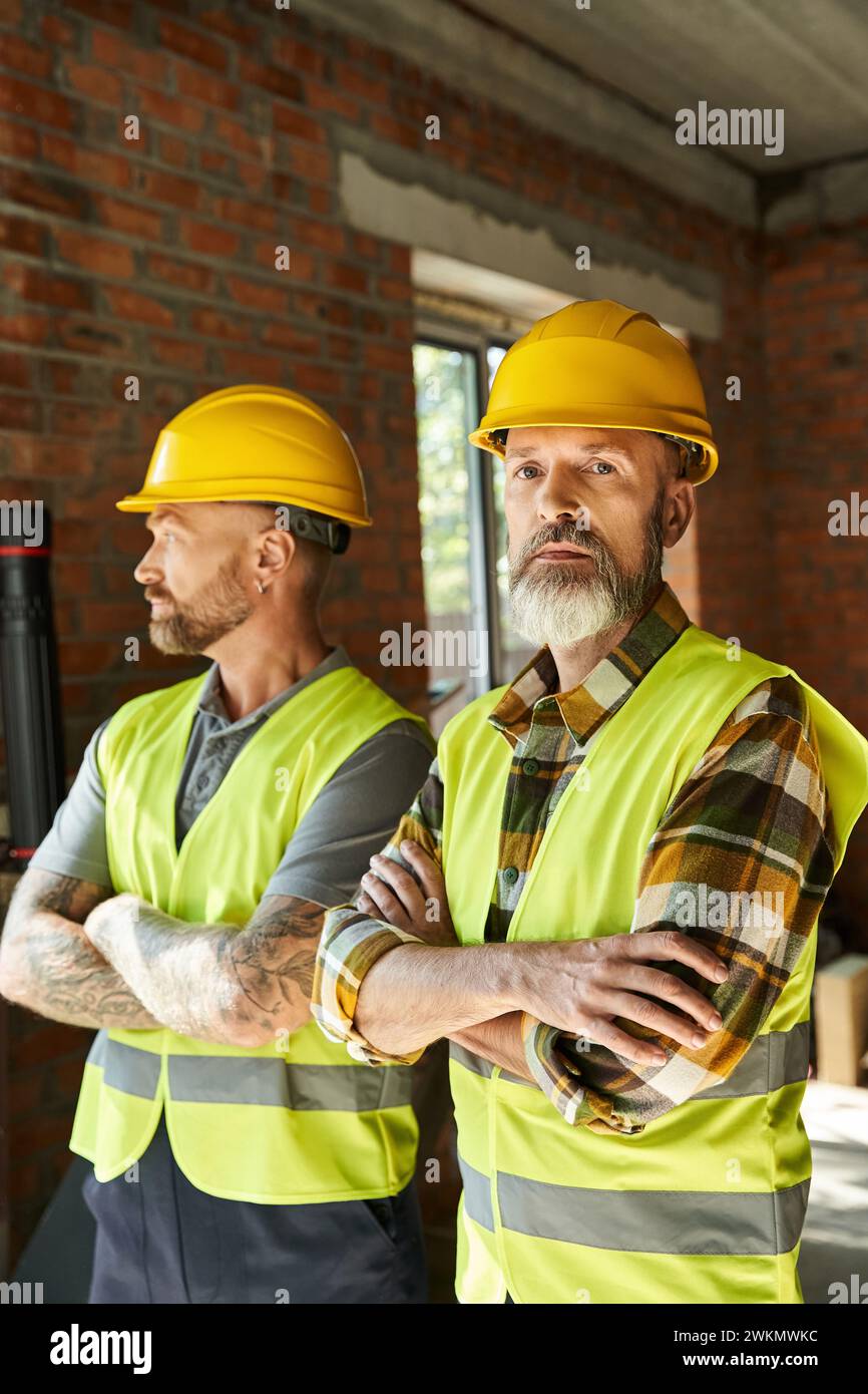 dedicated bearded cottage builders in safety helmets and vests posing ...