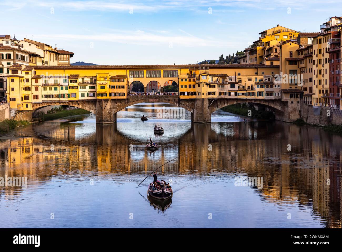 Boats are maneuvered down the Arno by the Ponte Vecchio, a magnificent ...