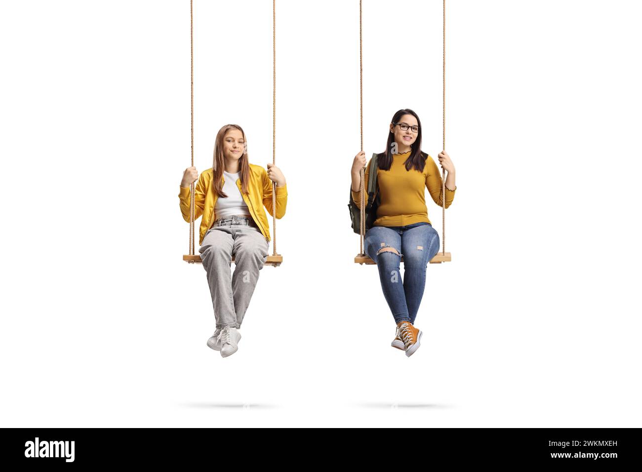 Female student and a teenage girl sitting on wooden swings isolated on ...