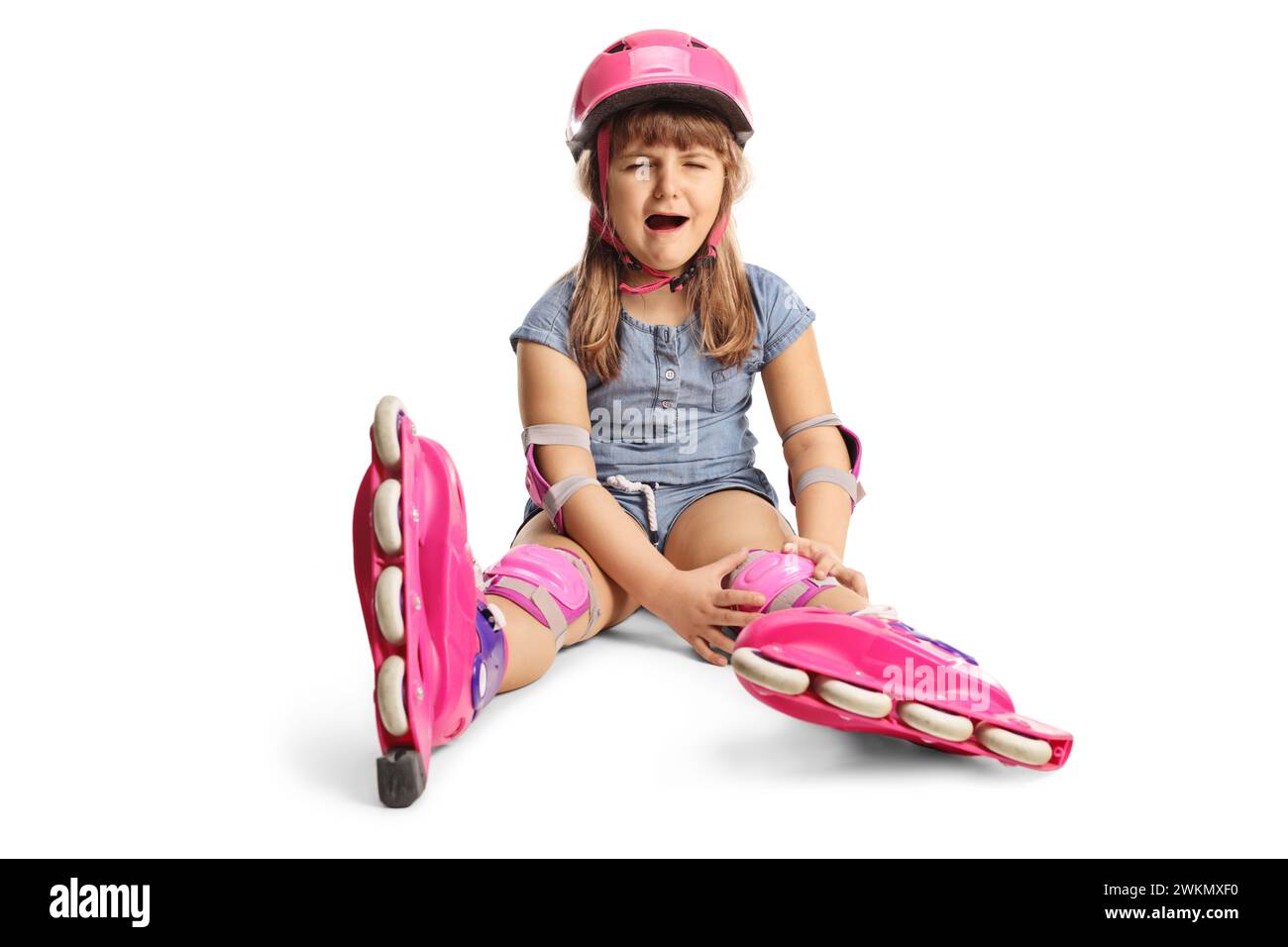 Girl with roller blades crying and sitting on the floor with an injured ...