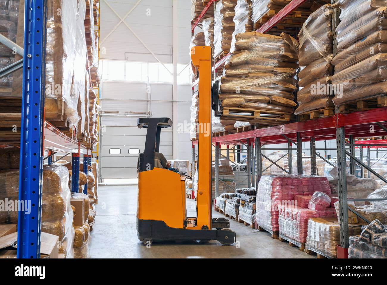 Forklift in a food warehouse loading goods onto a rack, warehouse ...