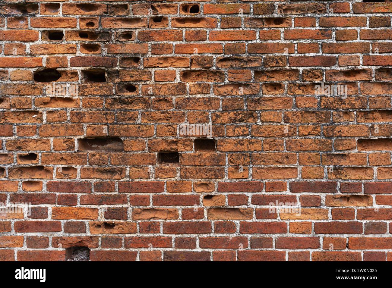 Flat texture of an old brick wall with bricks falling out in some ...