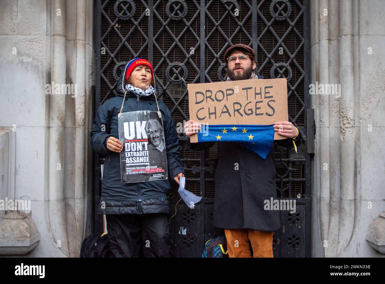 London, UK. 21st Feb, 2024. Two protesters hold placards and shout ...