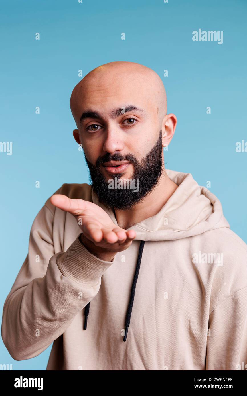 Young romantic arab man expressing affection while sending air kiss ...
