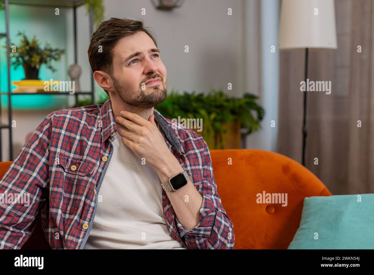 Upset Caucasian ill sick man holds hands over sore throat. Painful neck ...