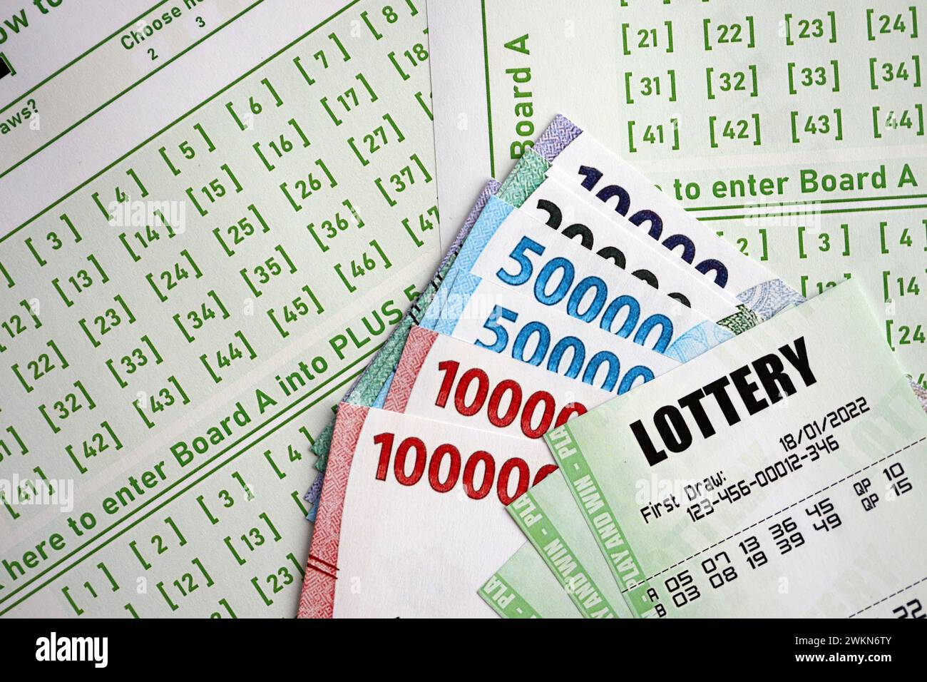 Green lottery tickets and indonesian money bills on blank with numbers ...
