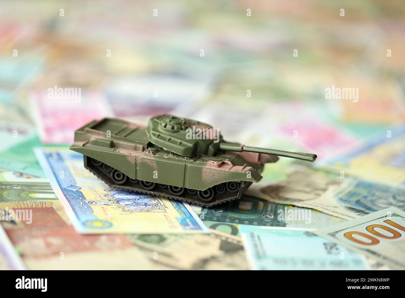 Small green tank on many banknotes of different currency. Background of ...