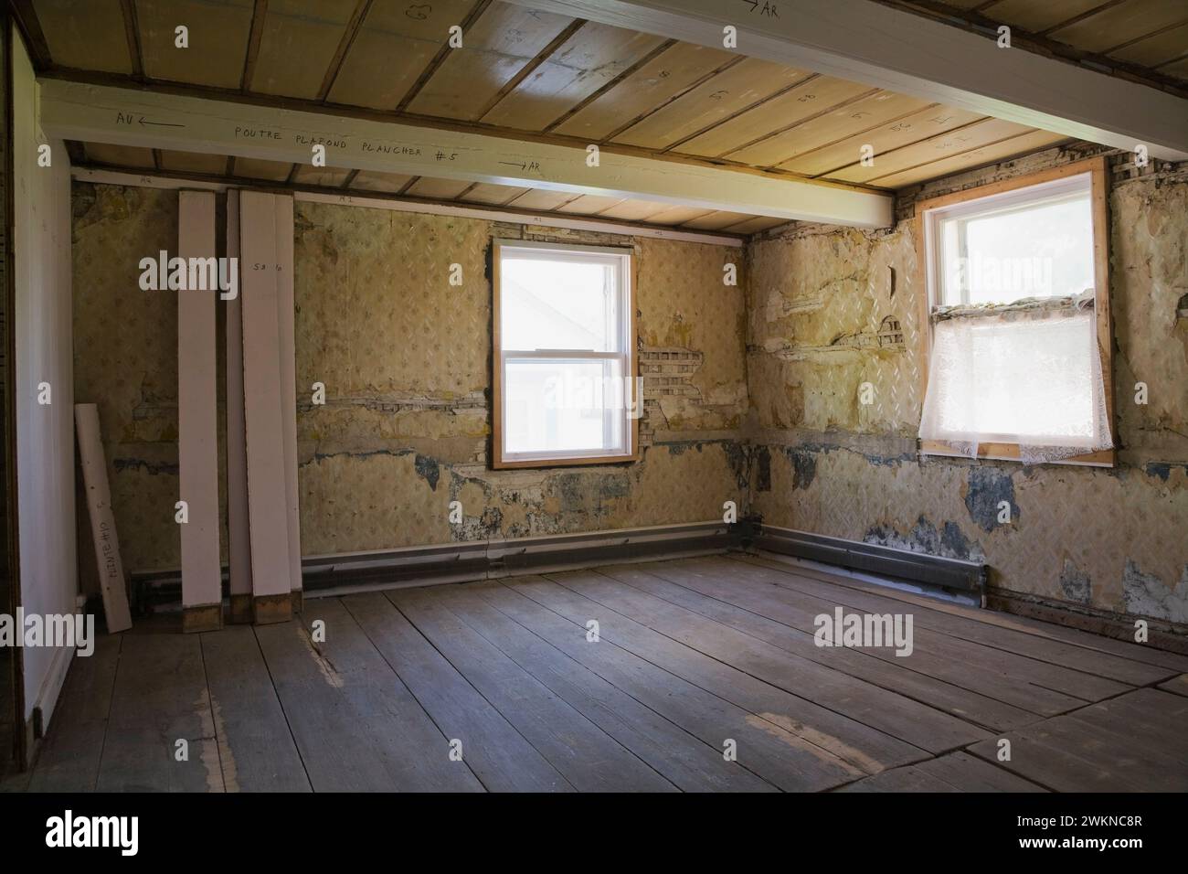 Empty room with partially demolished wallpaper, plaster and wooden ...