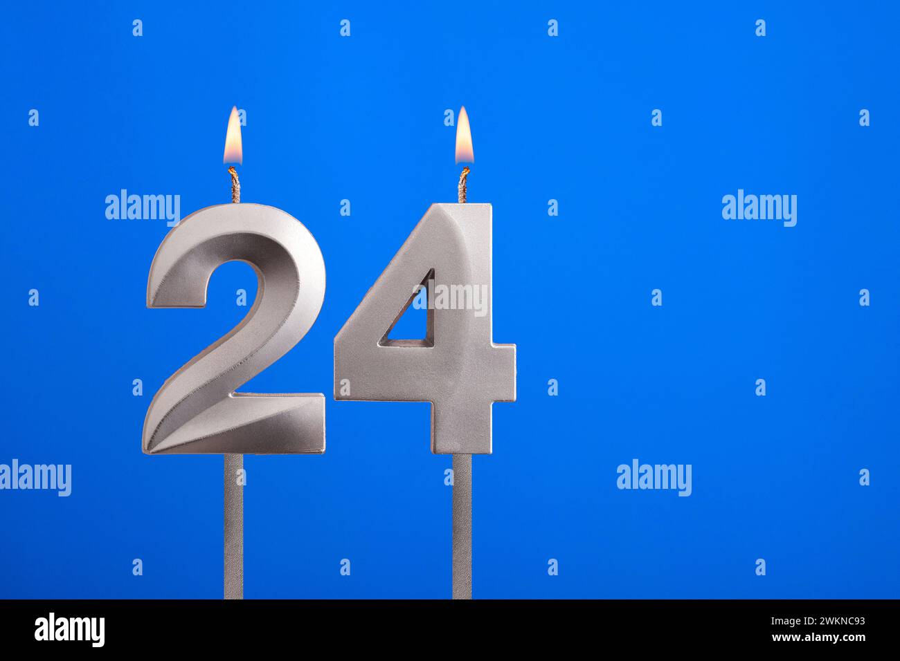 Birthday number 24 - Candle lit on blue background Stock Photo - Alamy