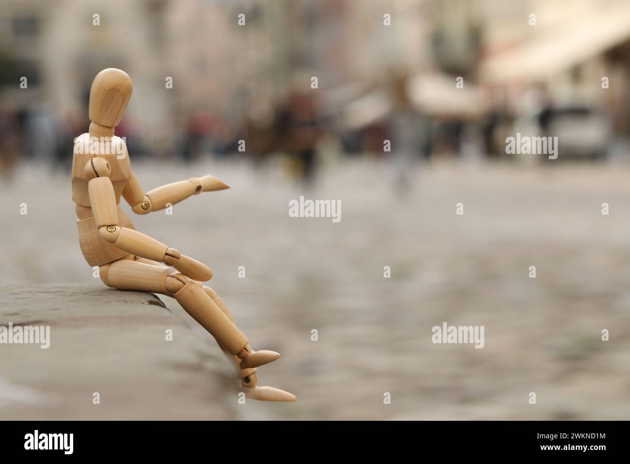 Wooden human figure sitting on curb outdoors, space for text Stock ...