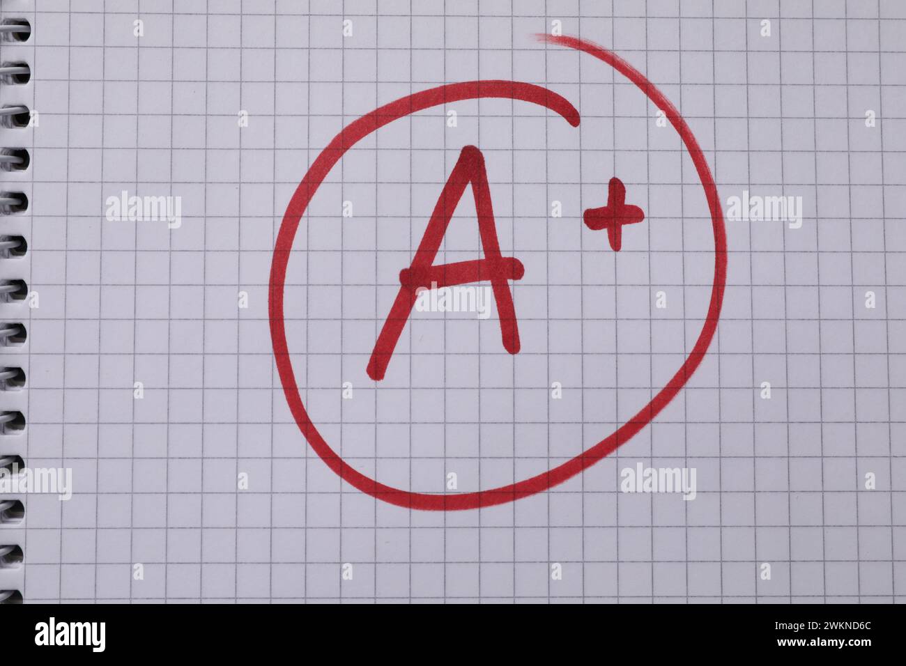 School grade. Red letter A with plus symbol on notebook paper, top view ...
