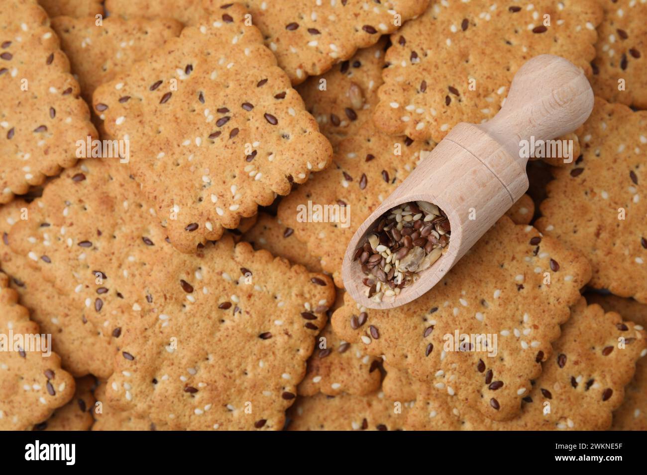 Scoop with grains on cereal crackers with flax and sesame seeds, top ...