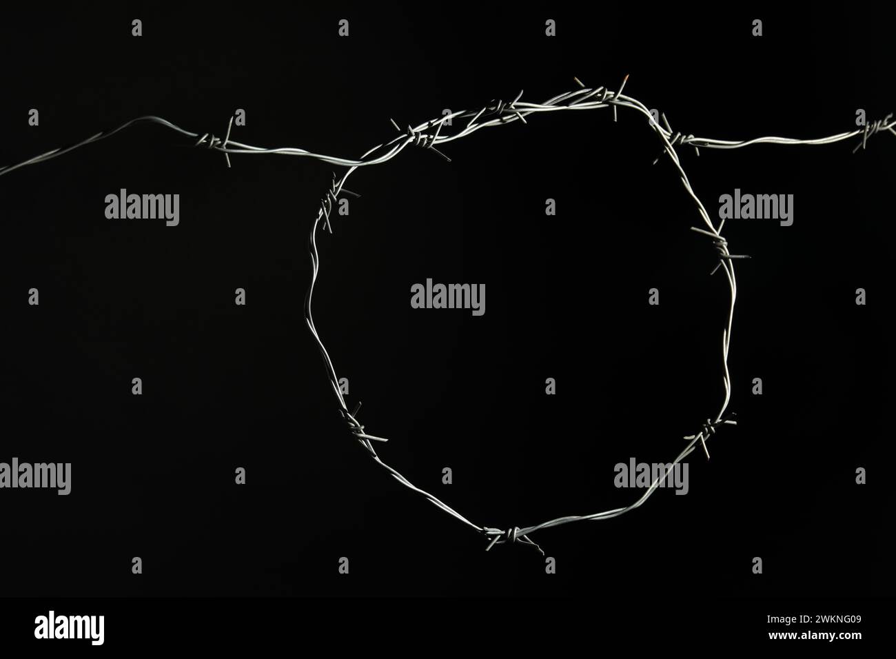 Shiny metal barbed wire on black background Stock Photo - Alamy