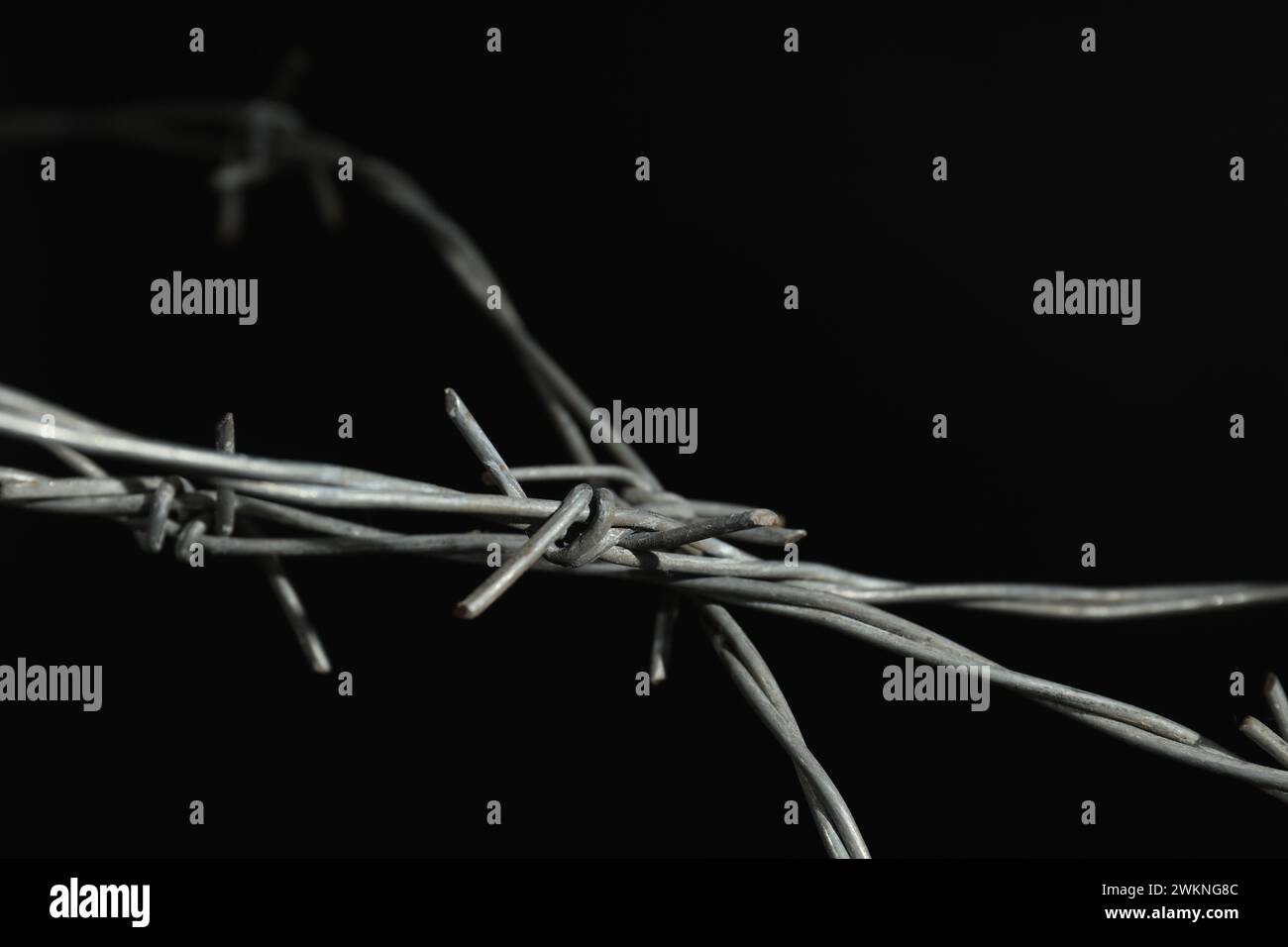 Shiny metal barbed wire on black background, closeup Stock Photo - Alamy