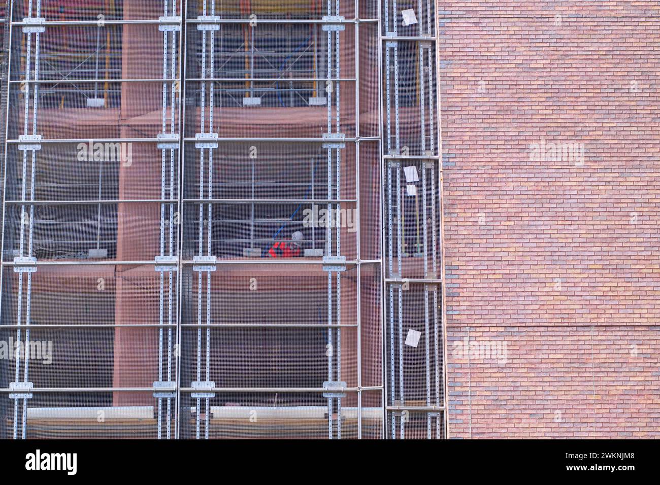 Scaffolding next to brick building showing abstract square patterns on ...