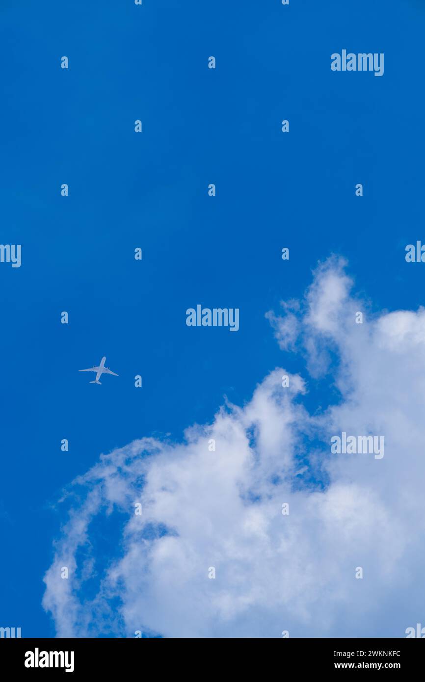Jet aeroplane in flight with a blue sky and fluffy cloud background ...
