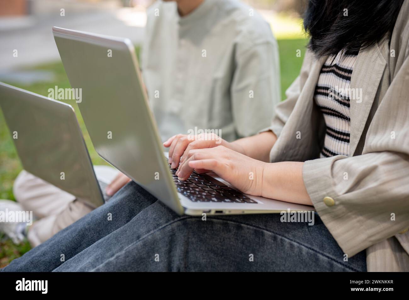 A close-up shot of two college students collaborating on work and using ...