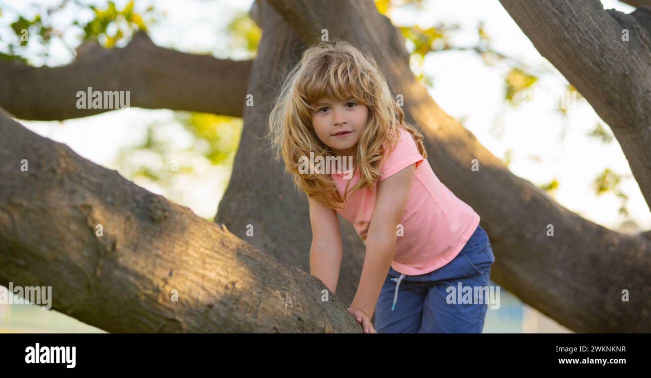 Kid climbing on a tree branch. Child climbs a tree Stock Photo - Alamy