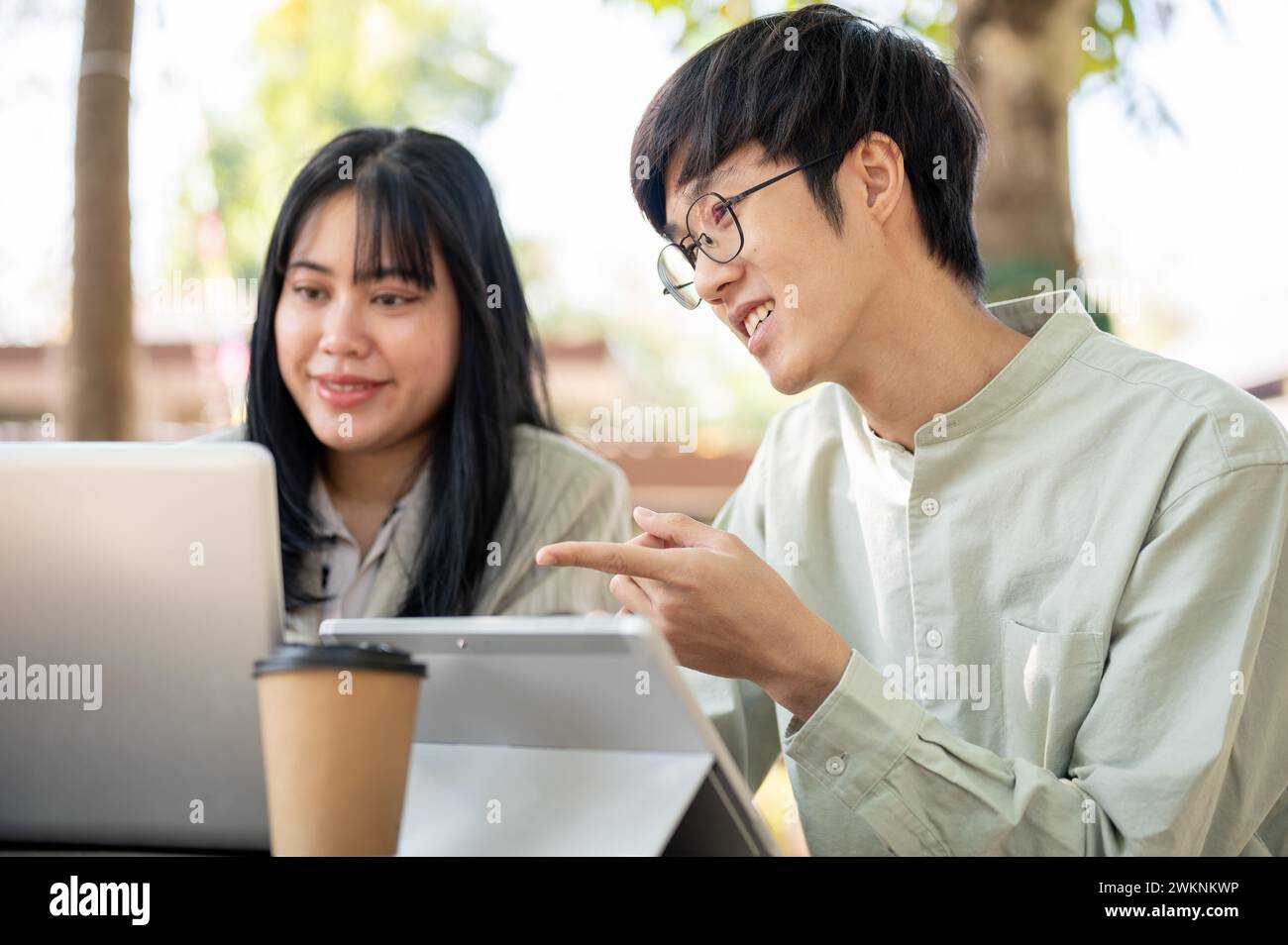 Two Asian male and female colleagues are discussing and collaborating ...