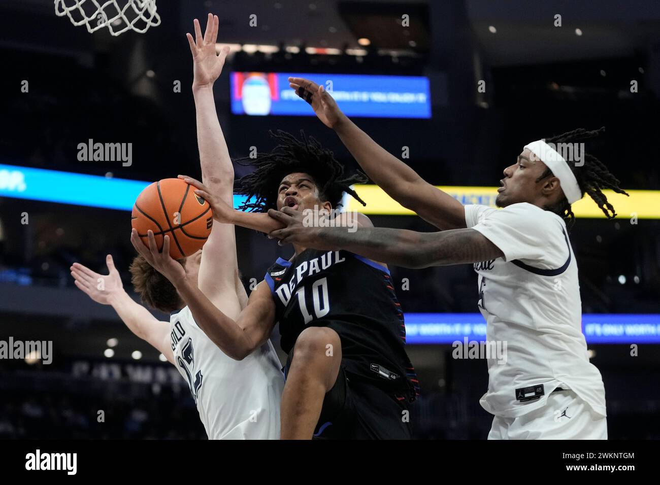 DePaul's Jaden Henley shoots between Marquette's Stevie Mitchell and ...