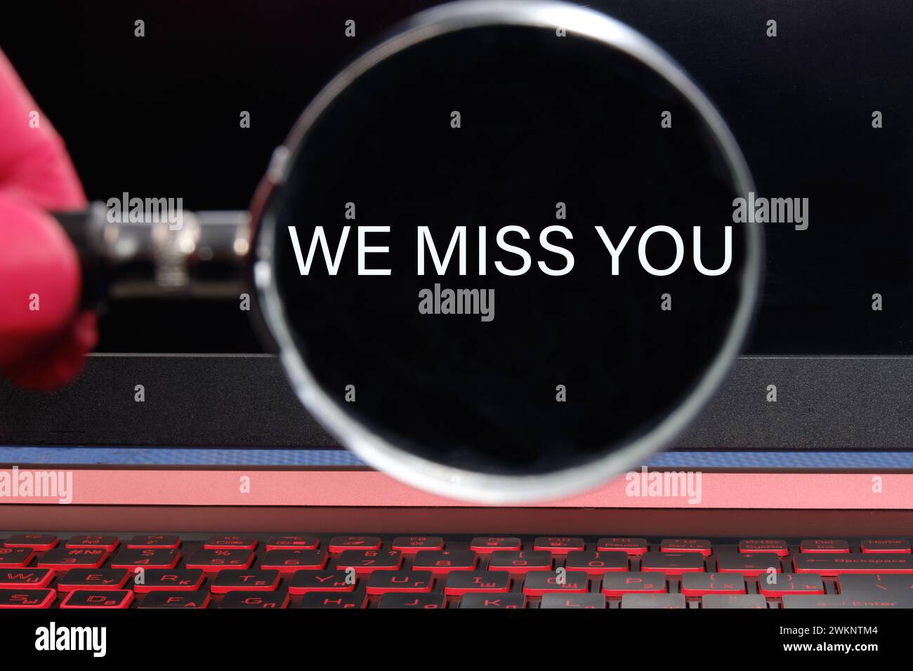 we miss you text written through a magnifying glass on a black laptop ...