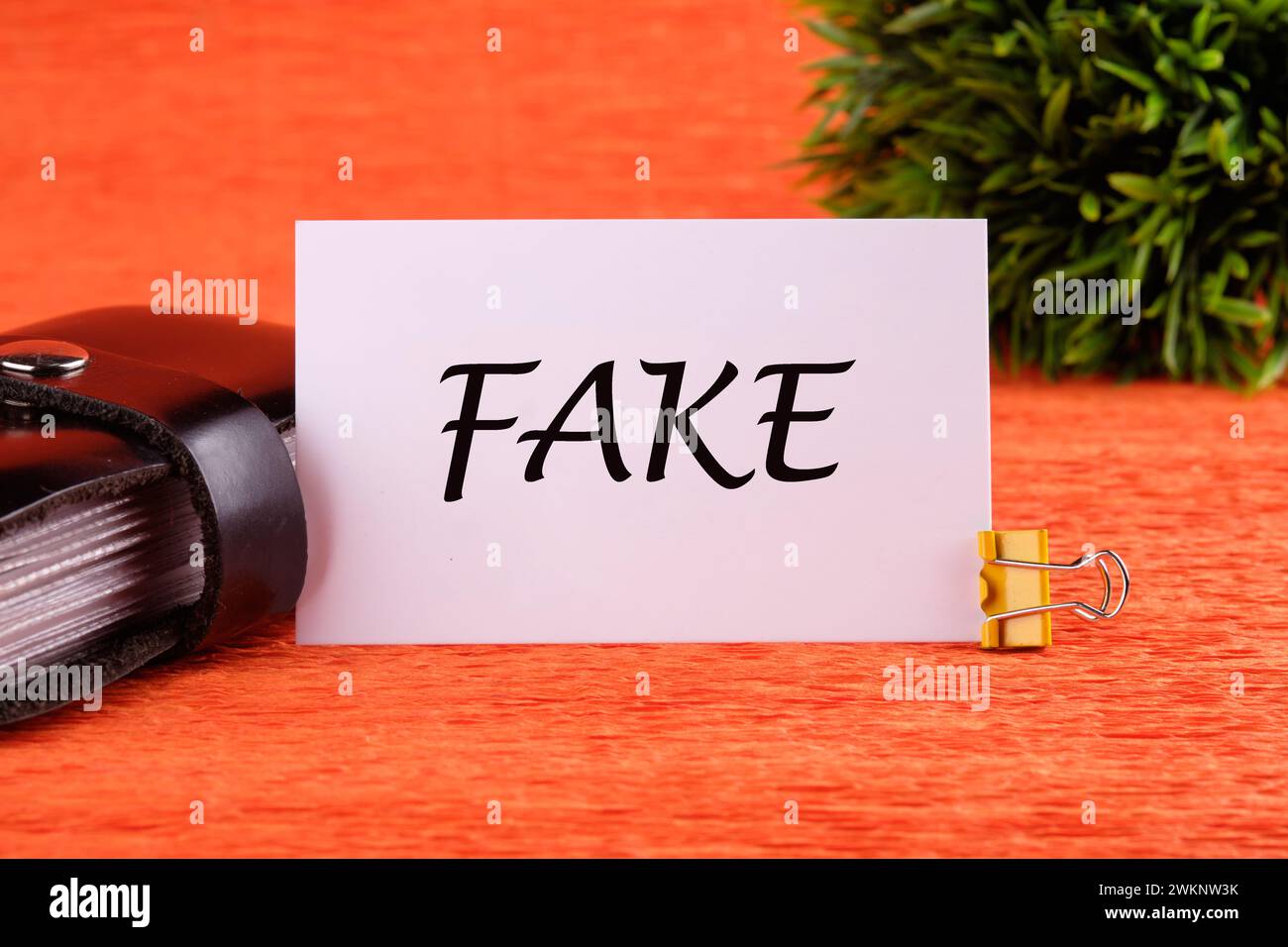 FAKE word written on a white card near the business card holder in ...