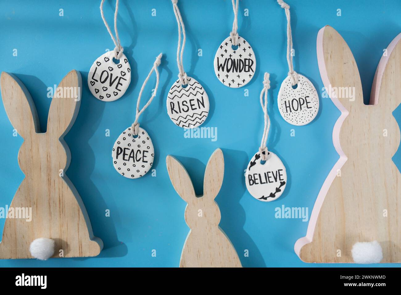Group of wooden bunny ears and clay Easter eggs with words RISEN HOPE ...
