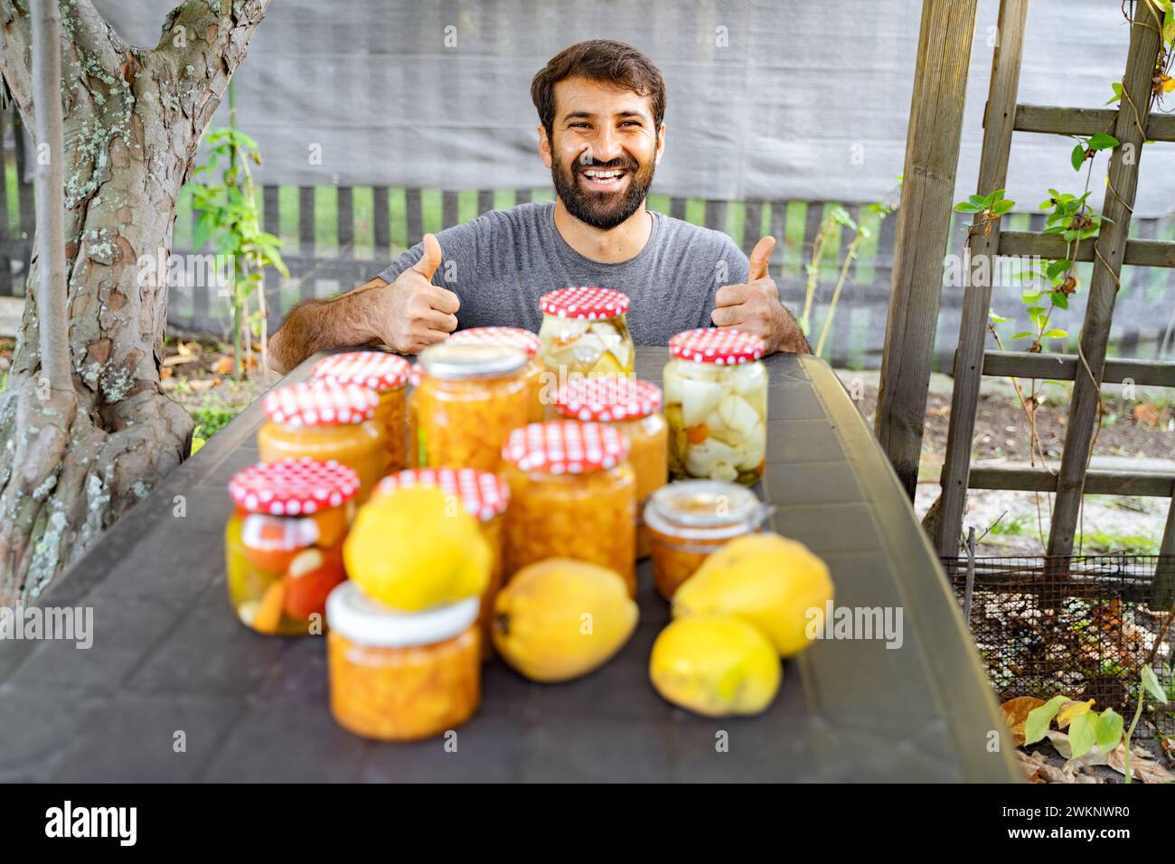 Happy man at table with natural foods and lemons, giving thumbs up ...