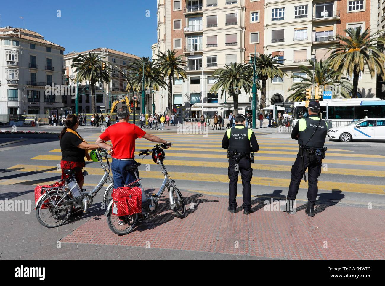 Spanish police officers stand next to tourists with bicycles in the ...