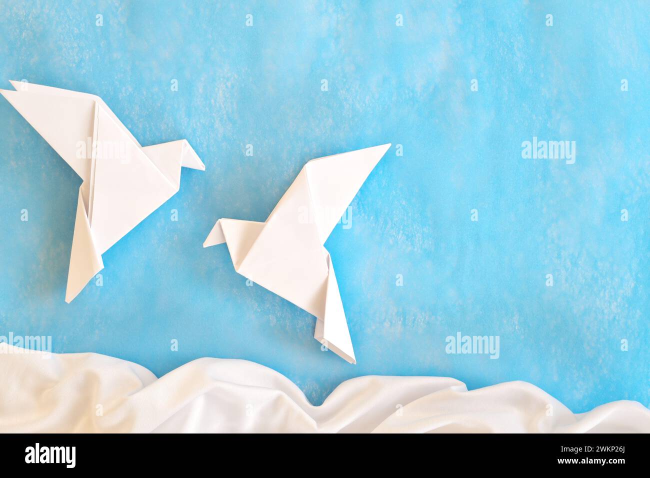 Two white dove paper cutout in blue background template with copy space ...