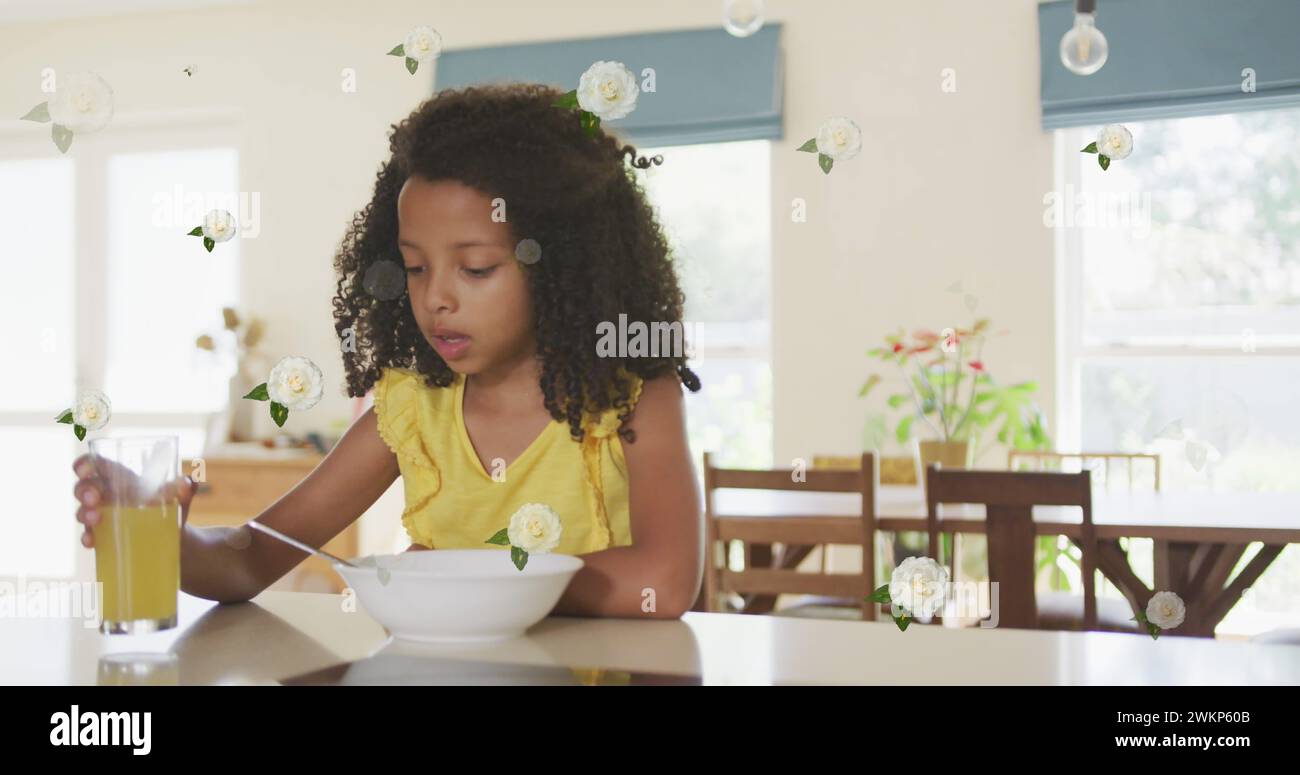 Image of roses over african american girl drinking juice and eating ...