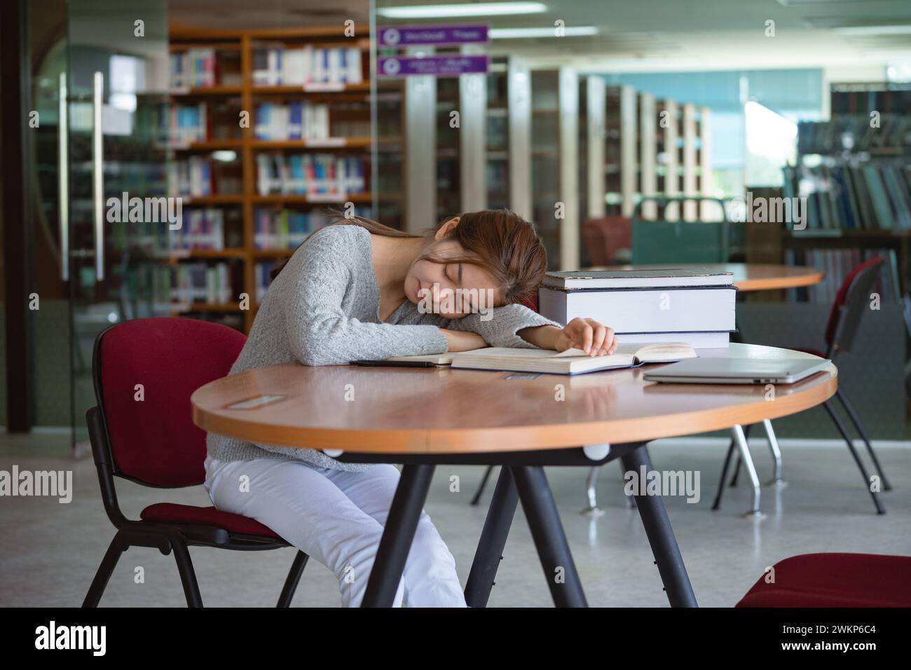 Tired woman student sleeping on desk in library Stock Photo - Alamy