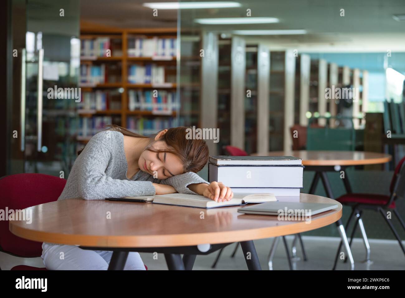 Tired woman student sleeping on desk in library Stock Photo - Alamy