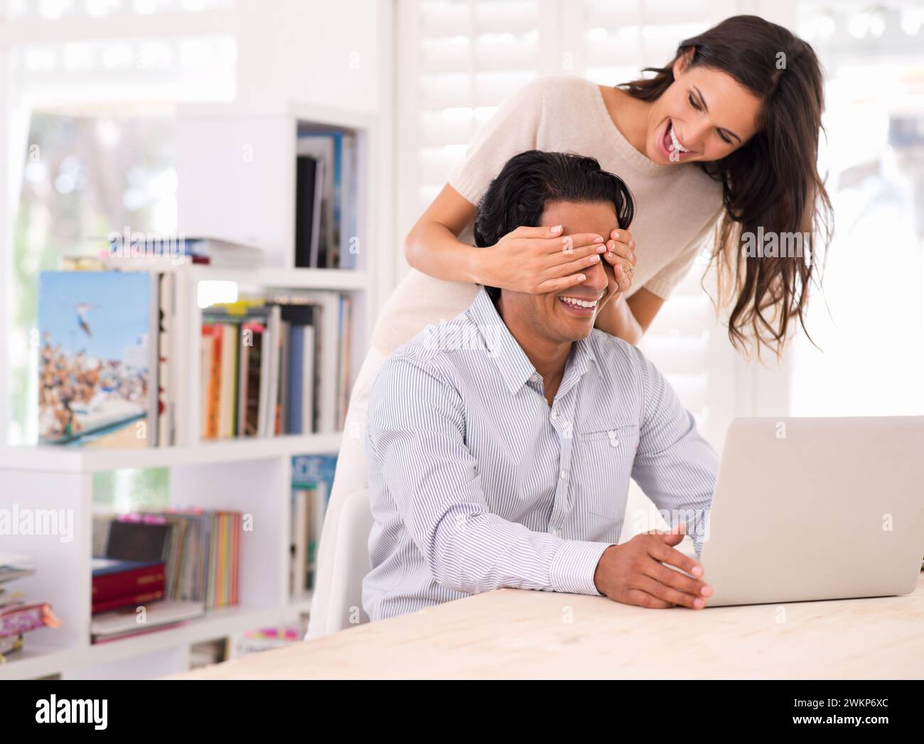 Couple, surprised and covering eyes in home office for anniversary ...