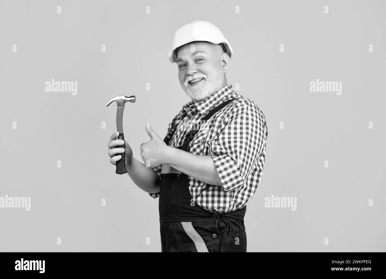 happy old man carpenter in helmet on yellow background. thumb up Stock ...