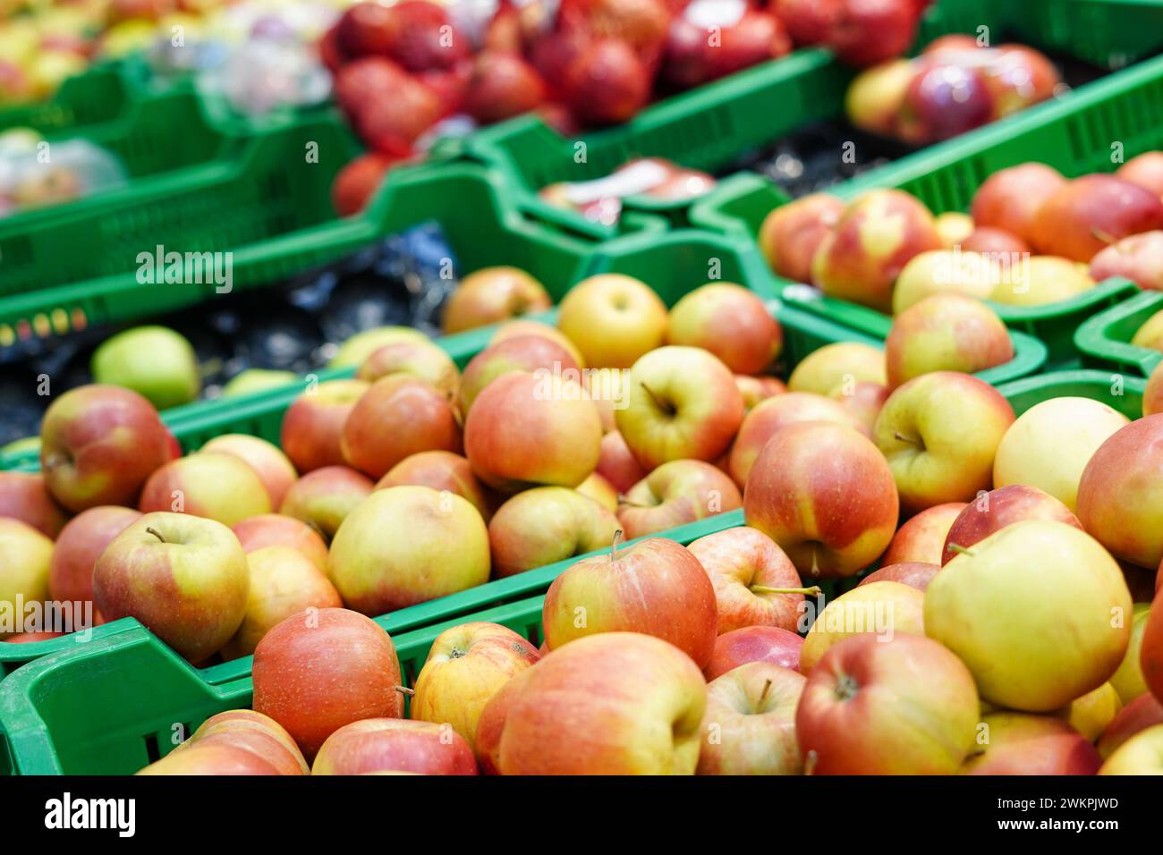 Red and yellow apples in the boxes in big grocery store. ripe apples ...