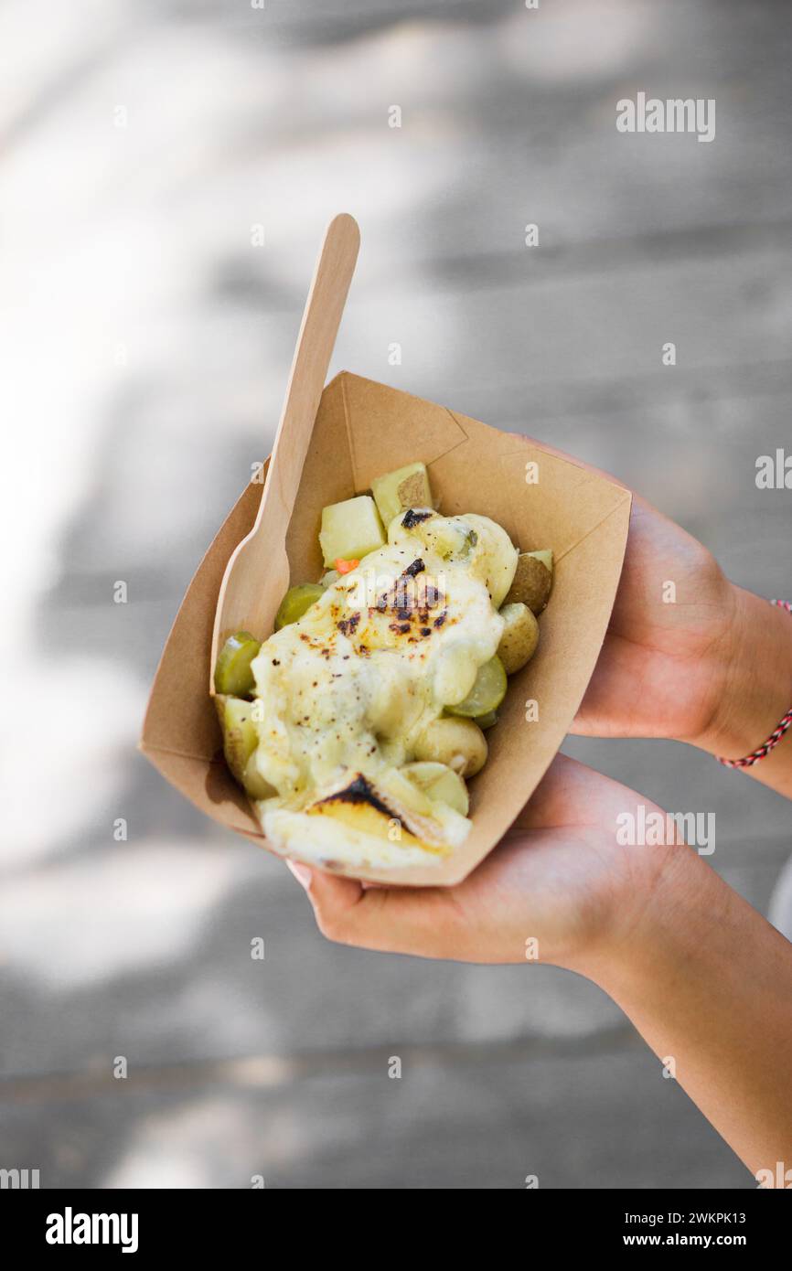 The hand-raised wooden bowl contained potato salad and topped it with ...