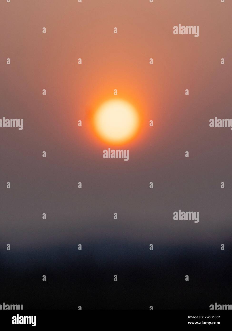 Rising sun in front of a blurred landscape. The picture was taken over ...