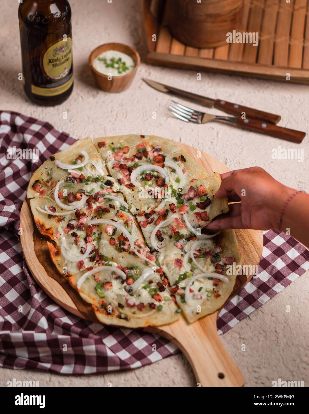 People's hands pick up pizza with pepperoni on a wooden cutting board ...